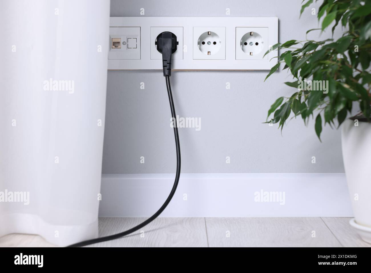Power sockets and electric plug on grey wall Stock Photo - Alamy