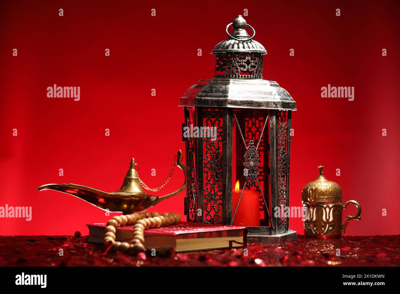 Arabic lantern, Quran, misbaha and Aladdin magic lamp on shiny red ...