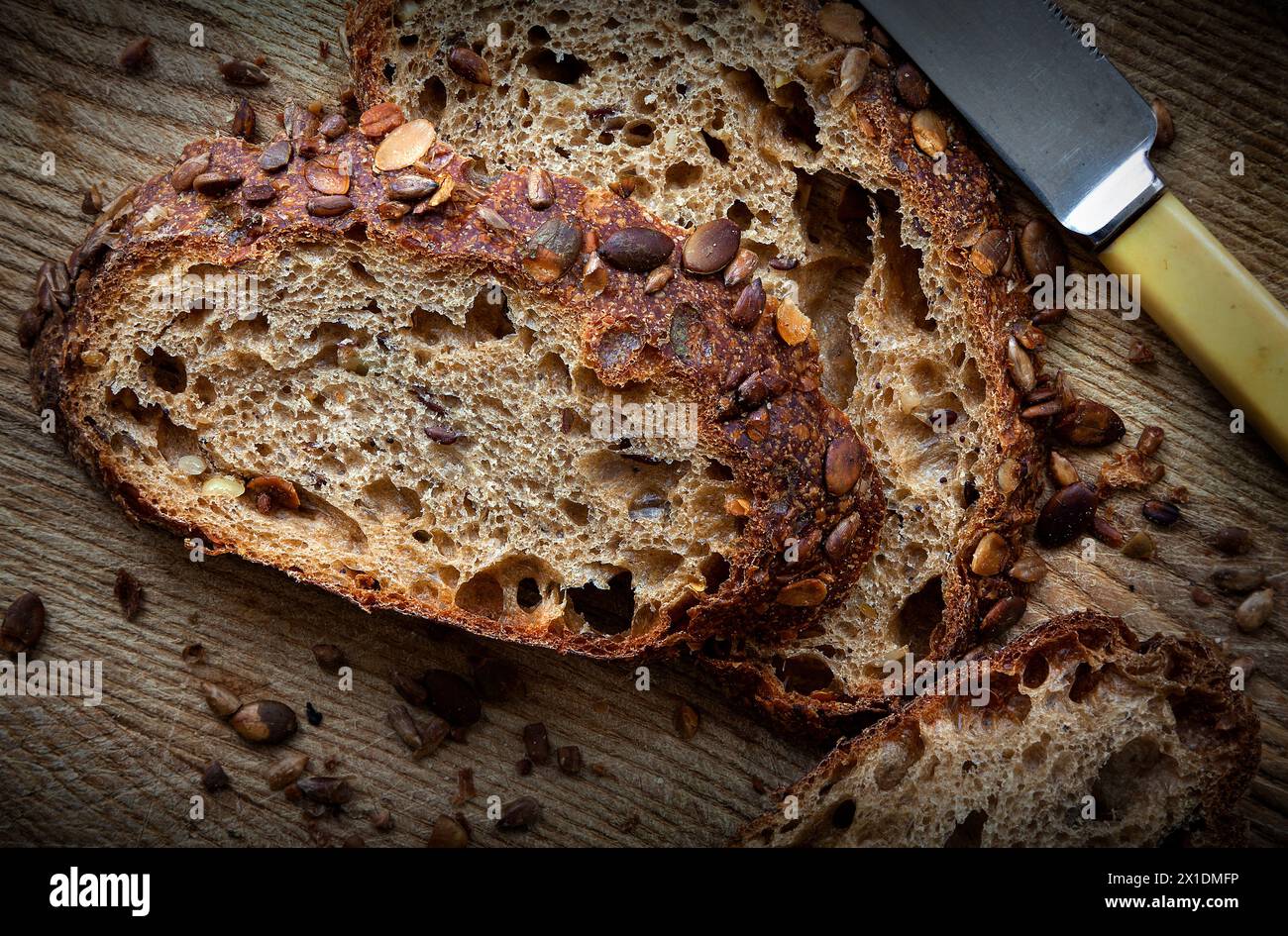 Sliced seeded sourdough loaf closeup on wooden cutting board with ...