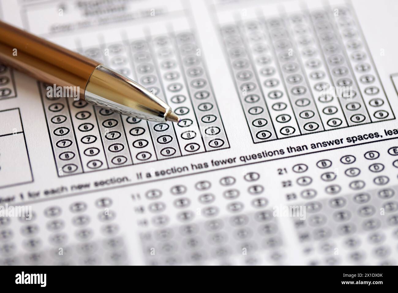 Blank educational test for students lies on table in classroom with pen ...