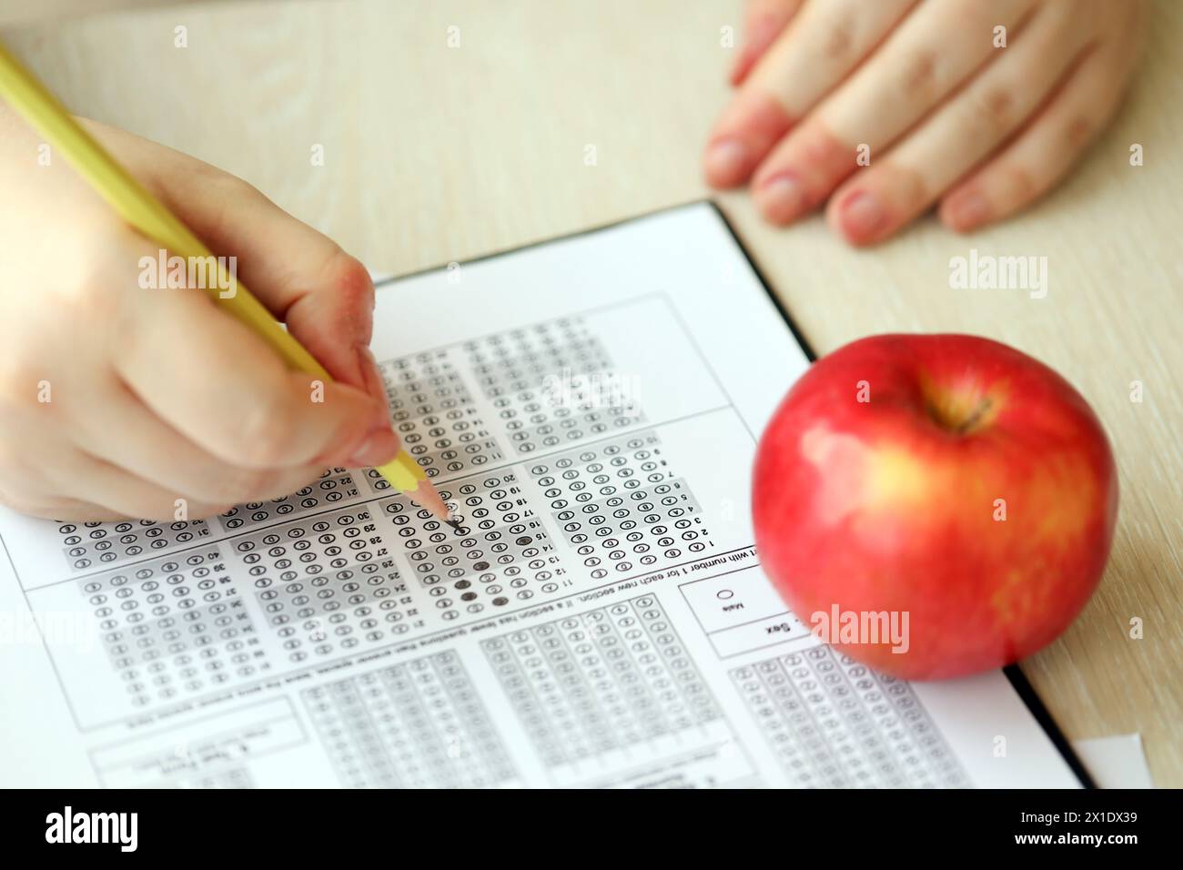 Female student hands testing in exercise and taking fill in exam paper ...