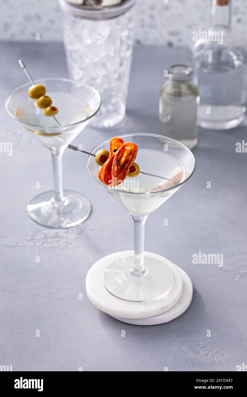 Martini with olive and salami garnishes, dirty martini cocktail in a ...