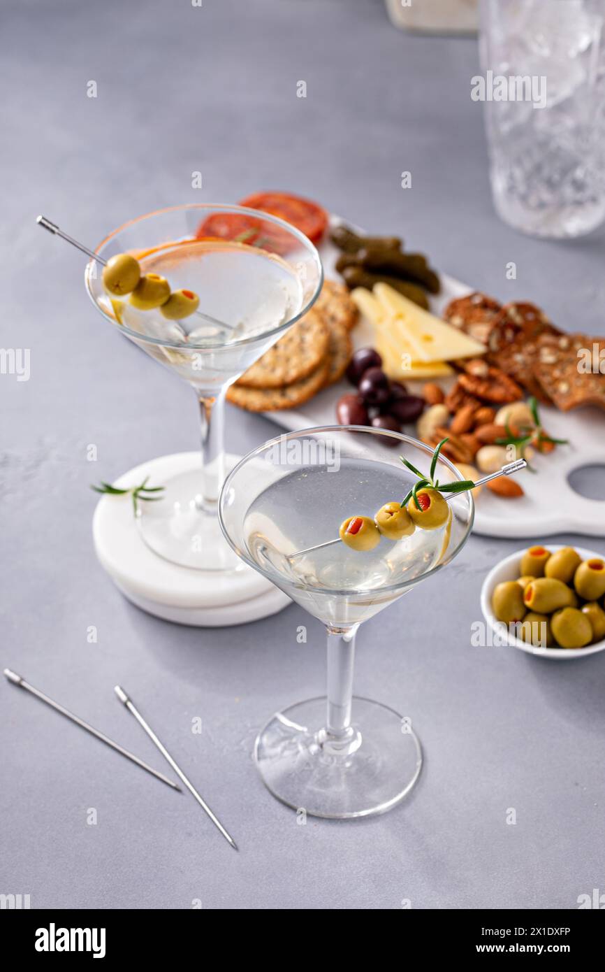 Traditional martini cocktail with olives garnish and charcuterie board ...