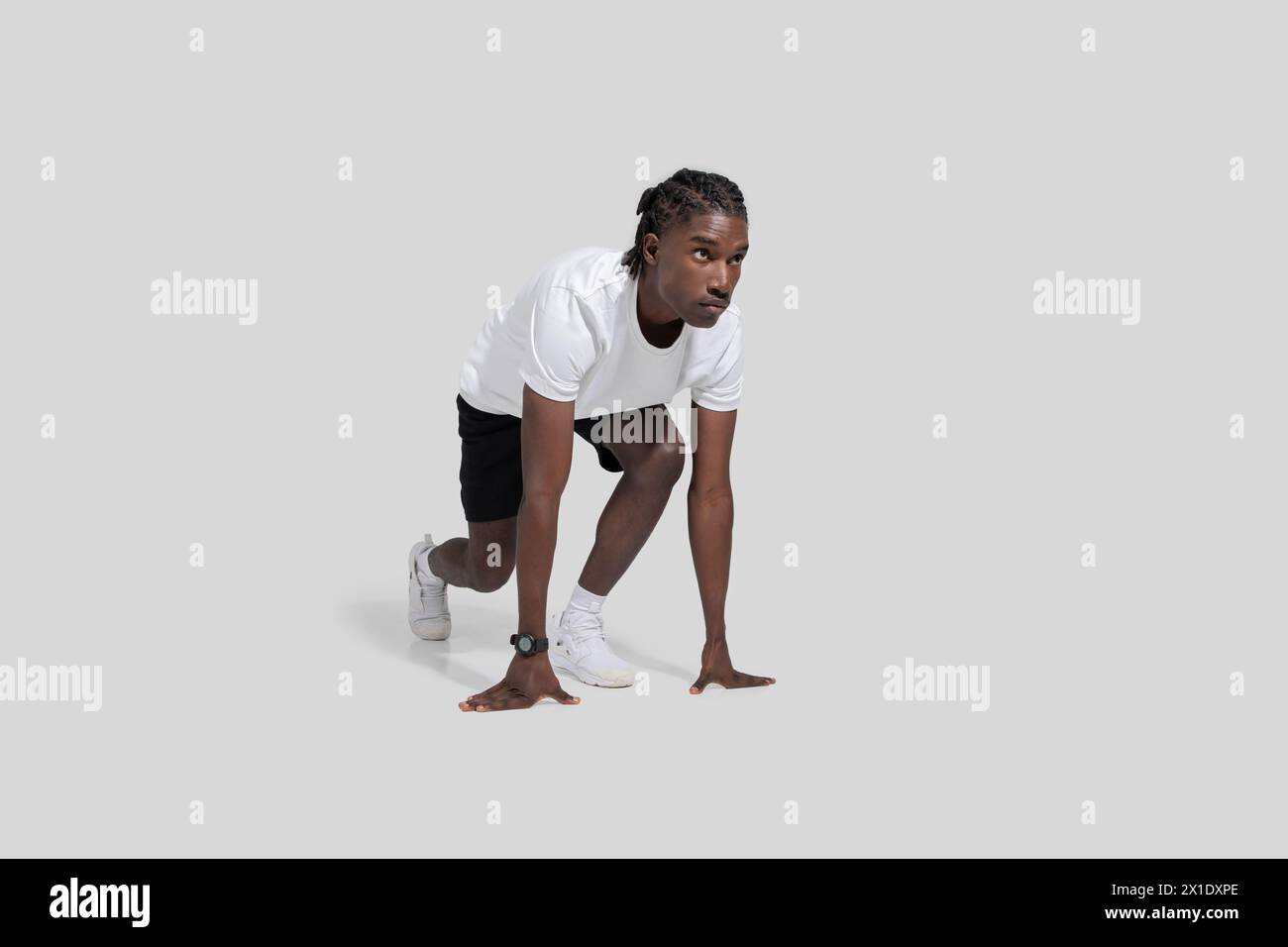Ready to run man in athletic pose on white background Stock Photo - Alamy