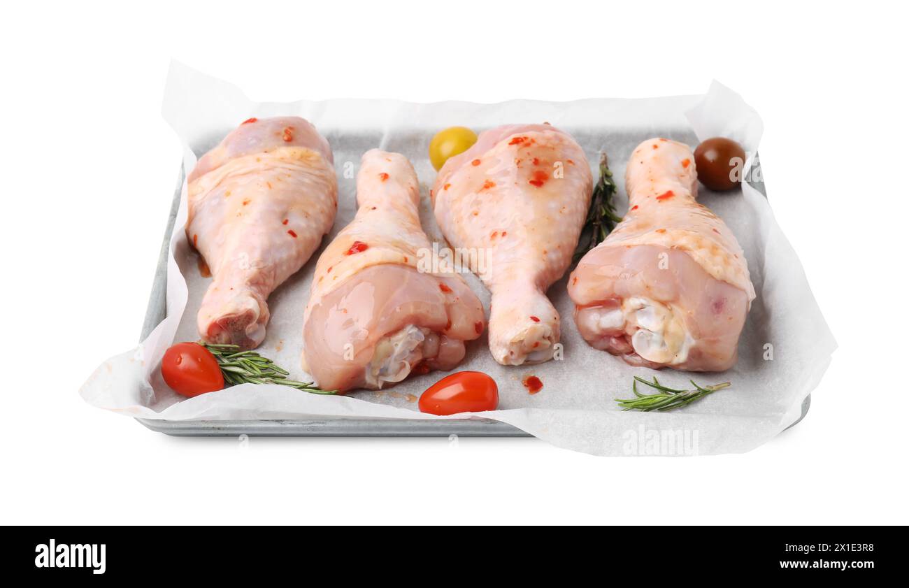 Raw marinated chicken drumsticks, rosemary and tomatoes in baking dish ...