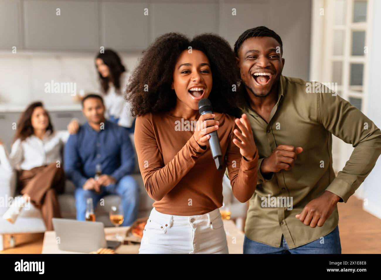 Friends laughing and singing together sharing a mic Stock Photo - Alamy