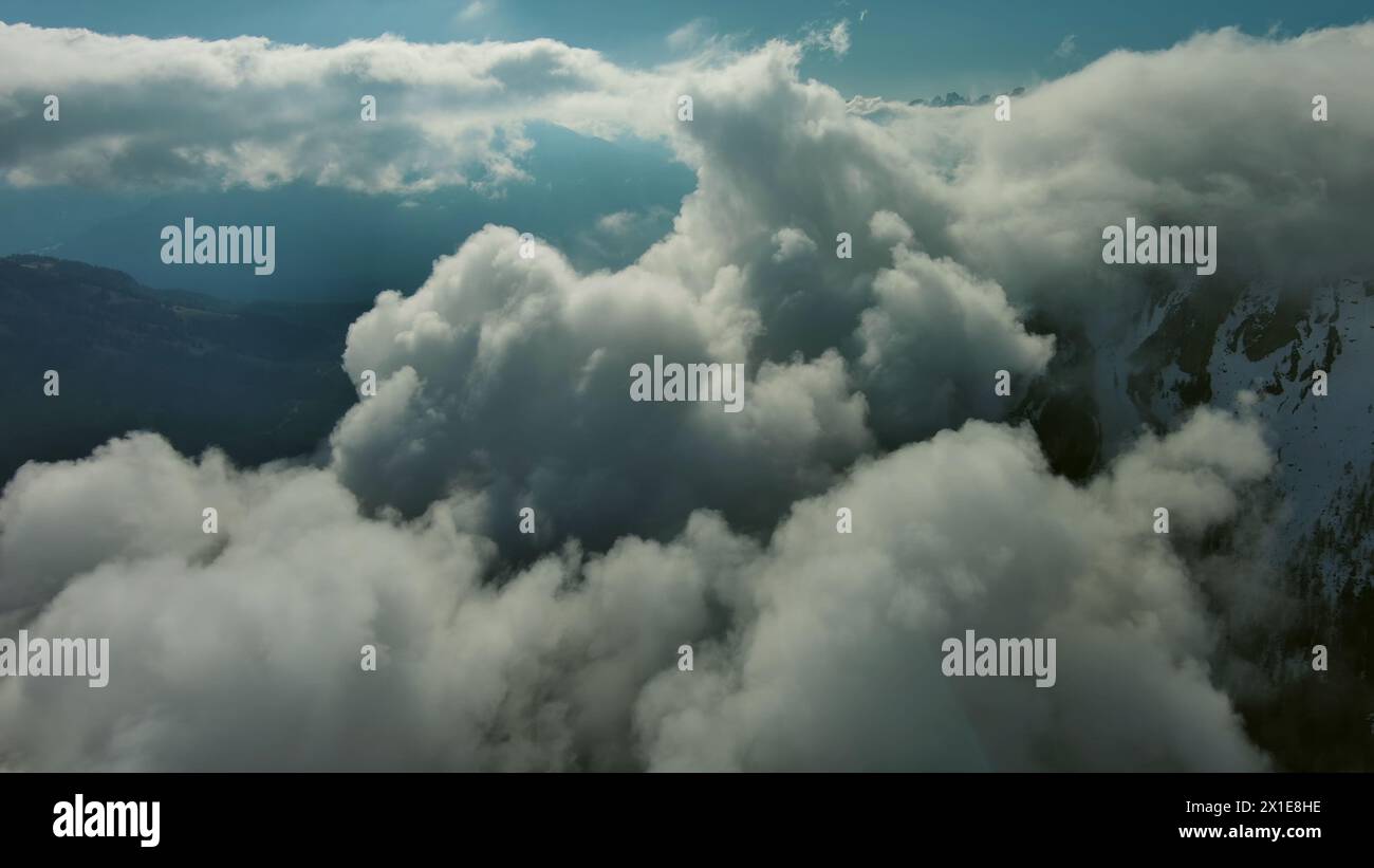 Flying through clouds between mountains Stock Photo - Alamy