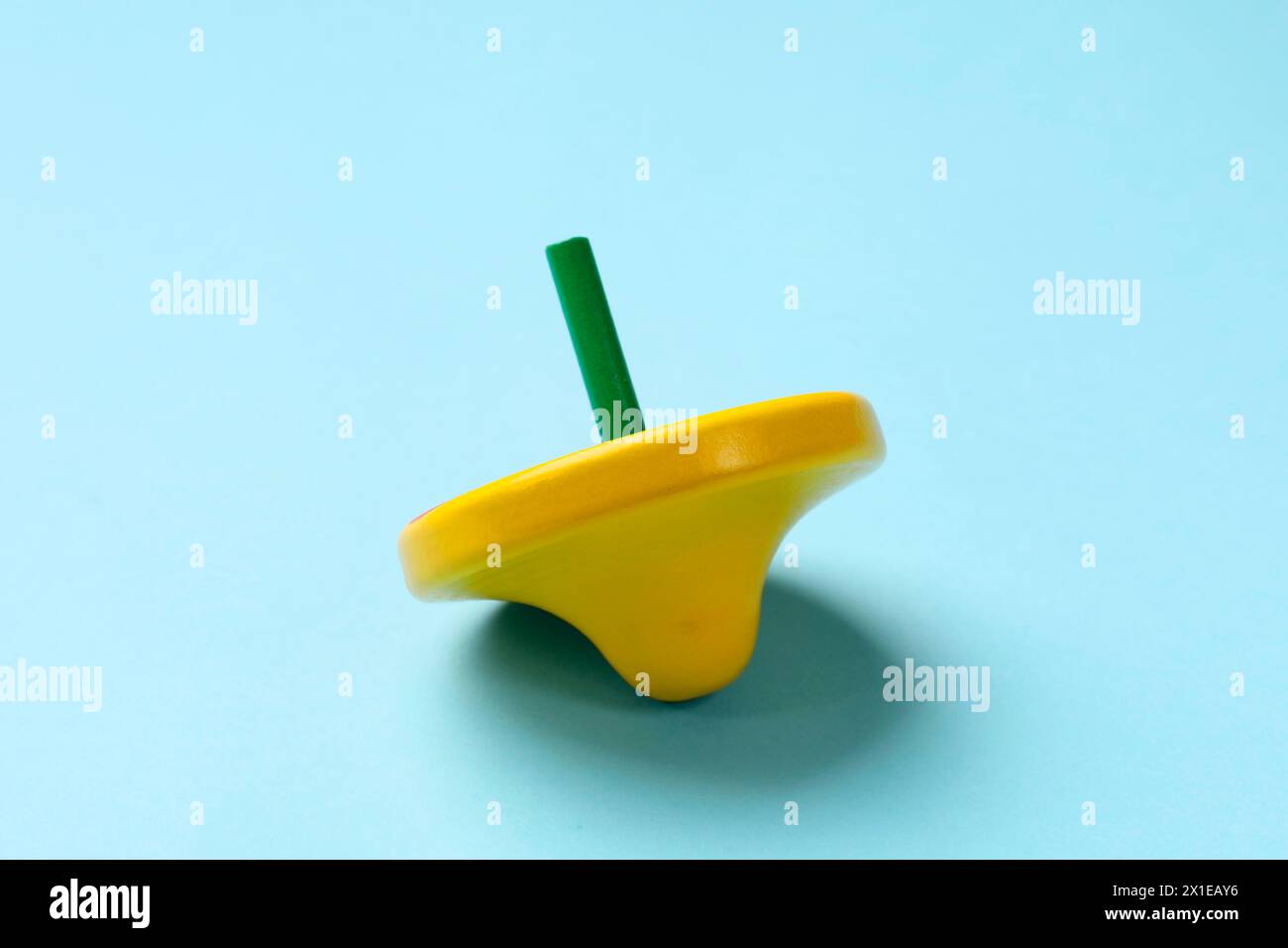 One yellow spinning top on light blue background, closeup Stock Photo ...