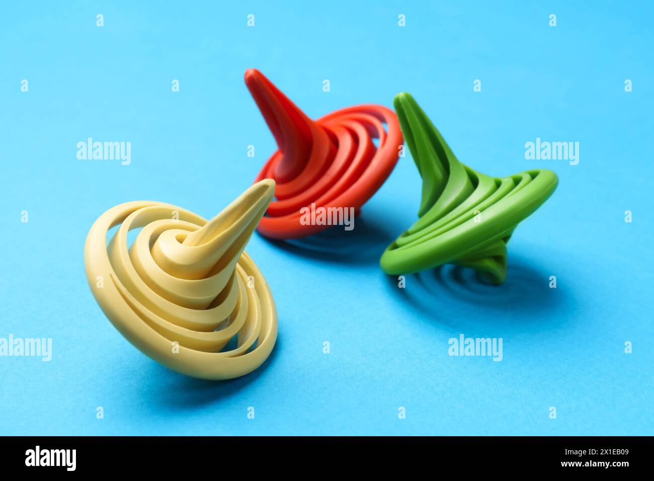 Many colorful spinning tops on light blue background, closeup Stock ...