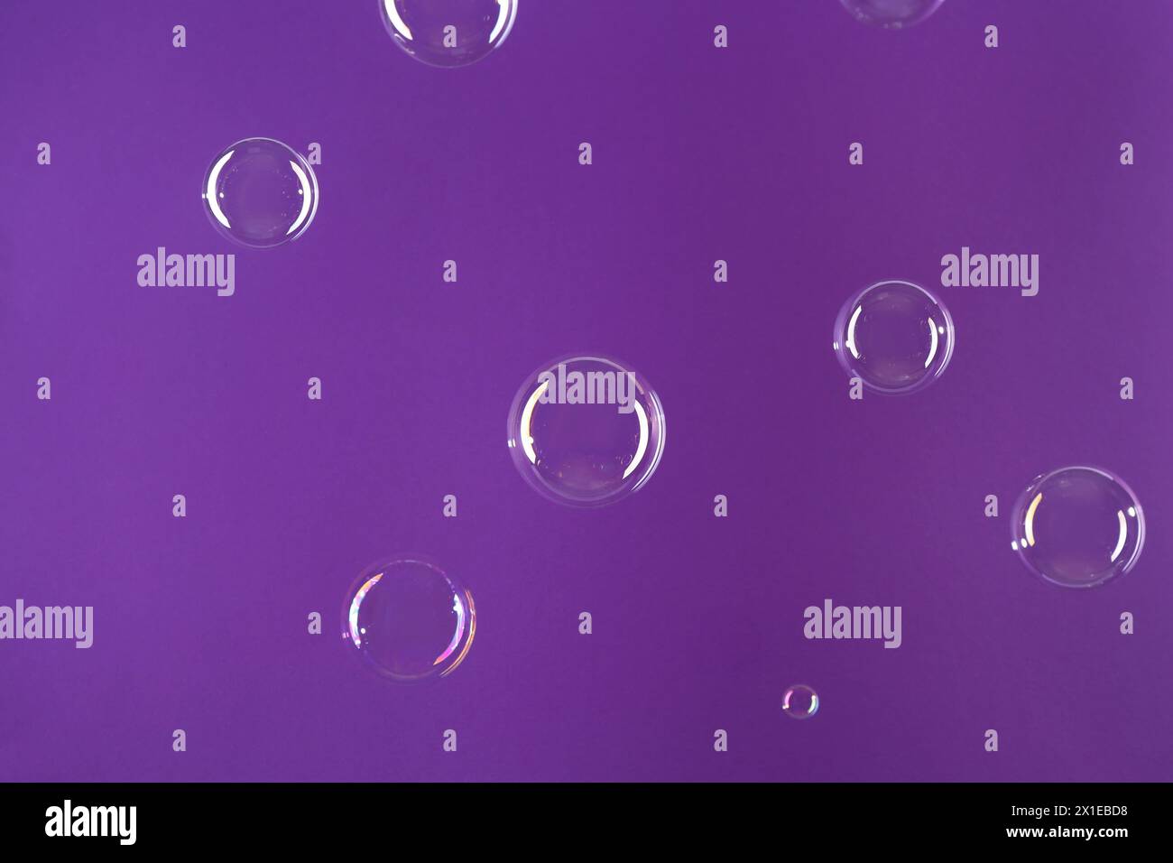 Beautiful transparent soap bubbles on violet background Stock Photo - Alamy