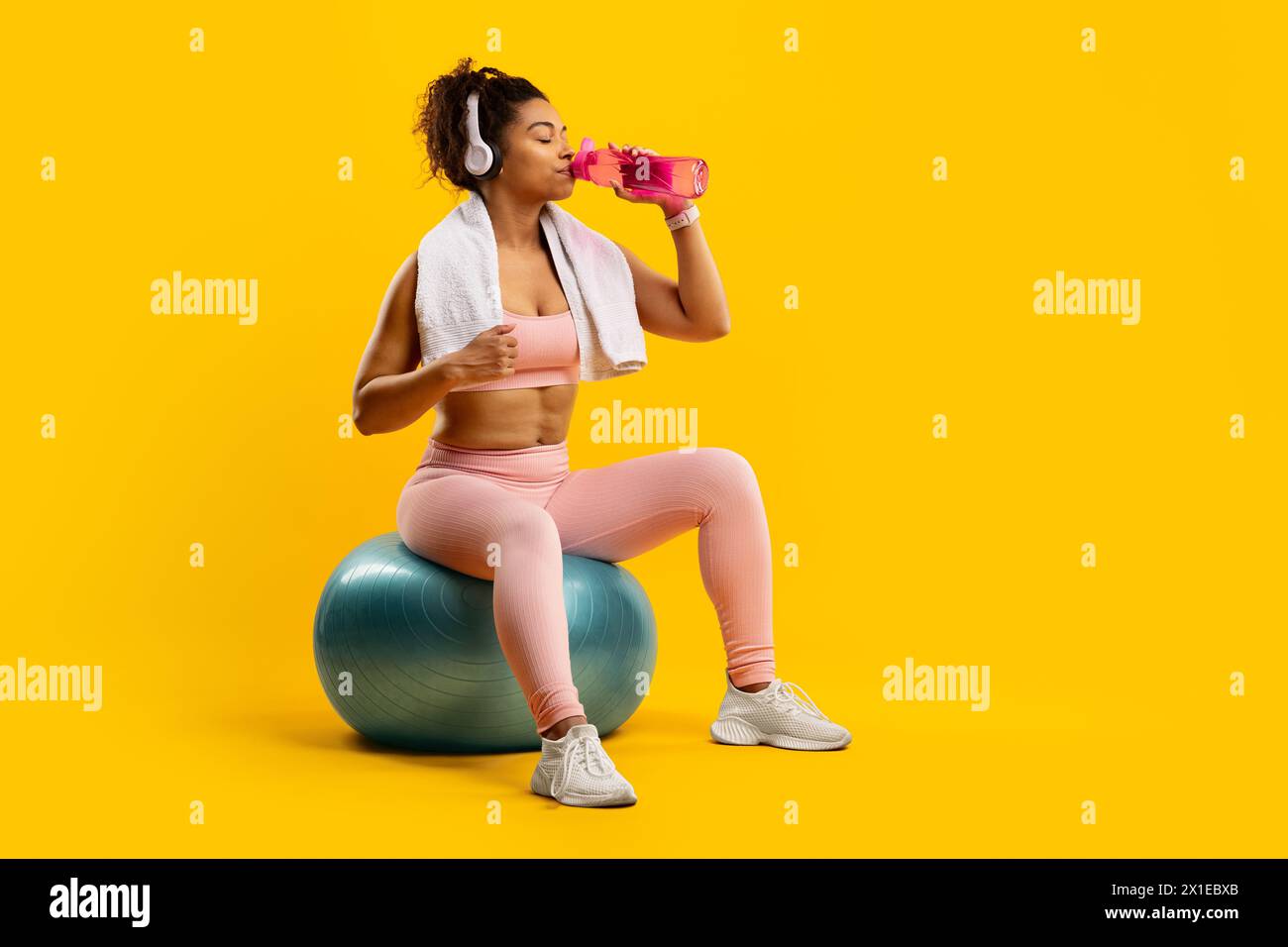 Fitness lady drinking water on a gym ball Stock Photo - Alamy