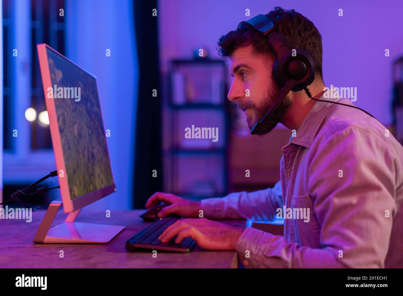 Engaged man gamer playing in neon lighting Stock Photo - Alamy
