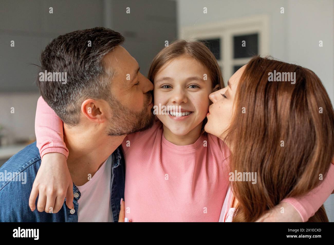 Family moments with affectionate parents kissing child Stock Photo - Alamy