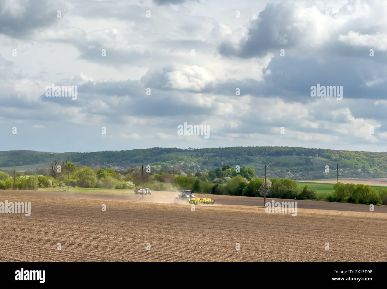 Tractor and field. Farm tractor with trailer seeder making sowing ...