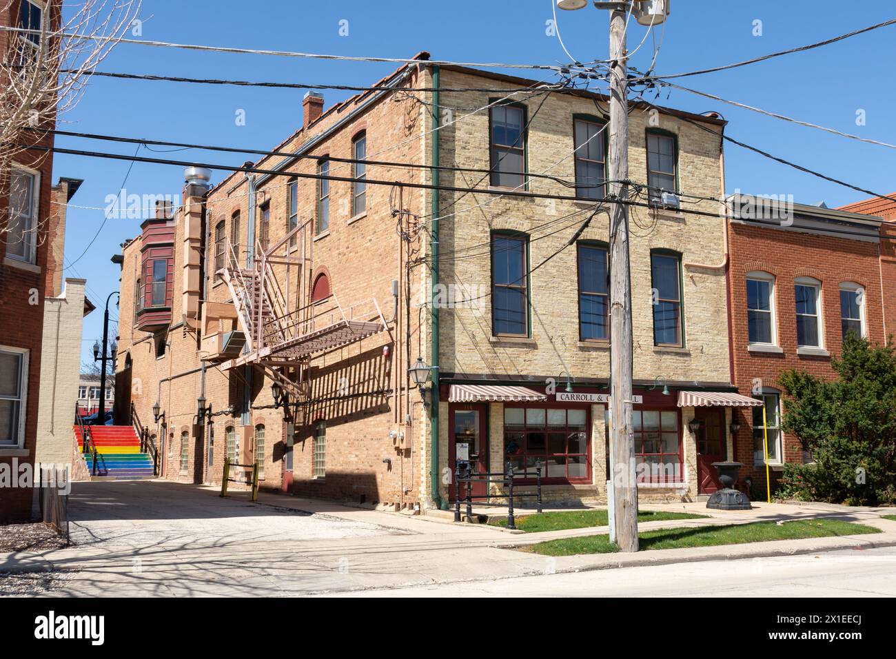 Old storefront and alleyway with staircase painted in rainbow colors ...