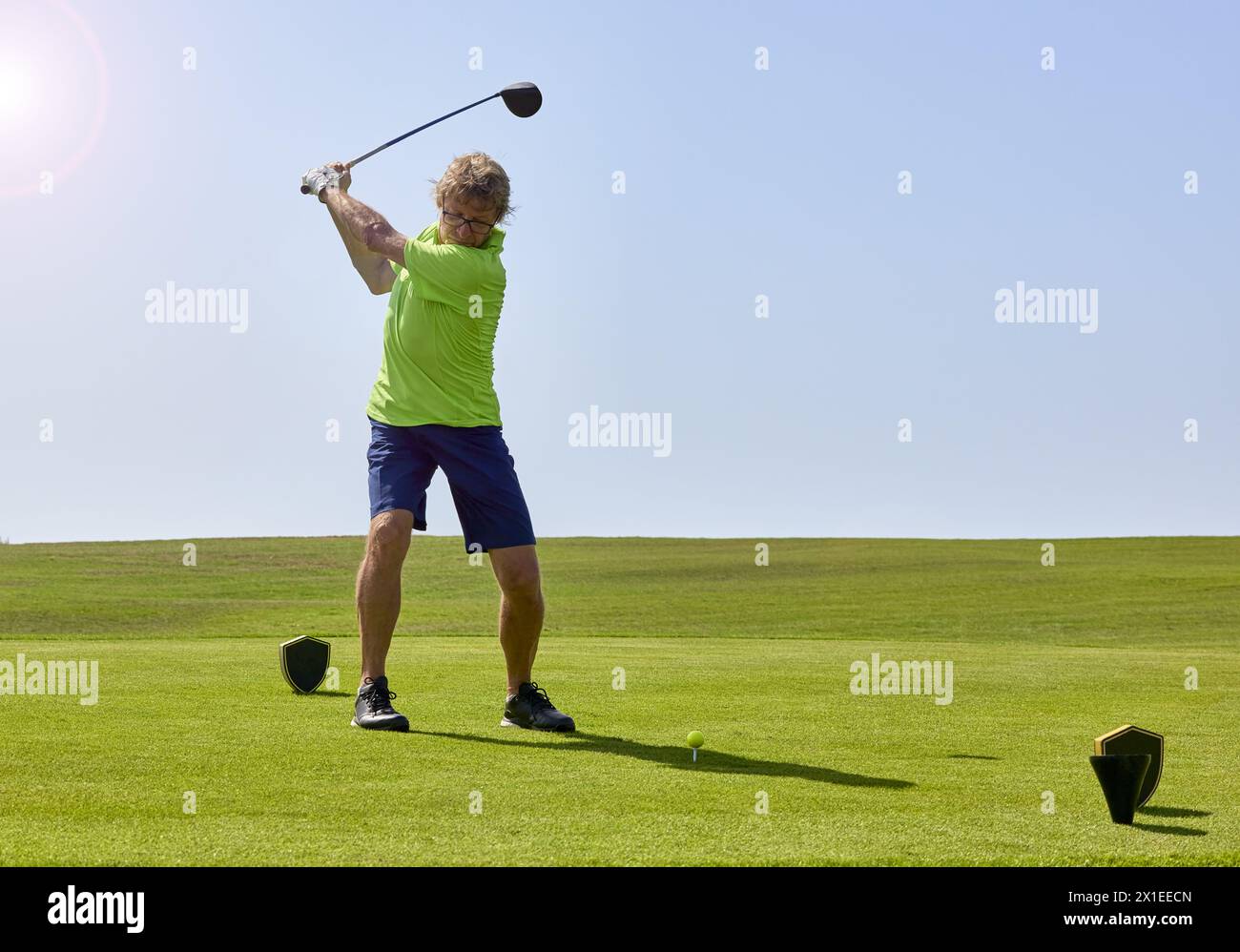 Golfer on a golf course, ready to tee off. Golfer with golf club ...