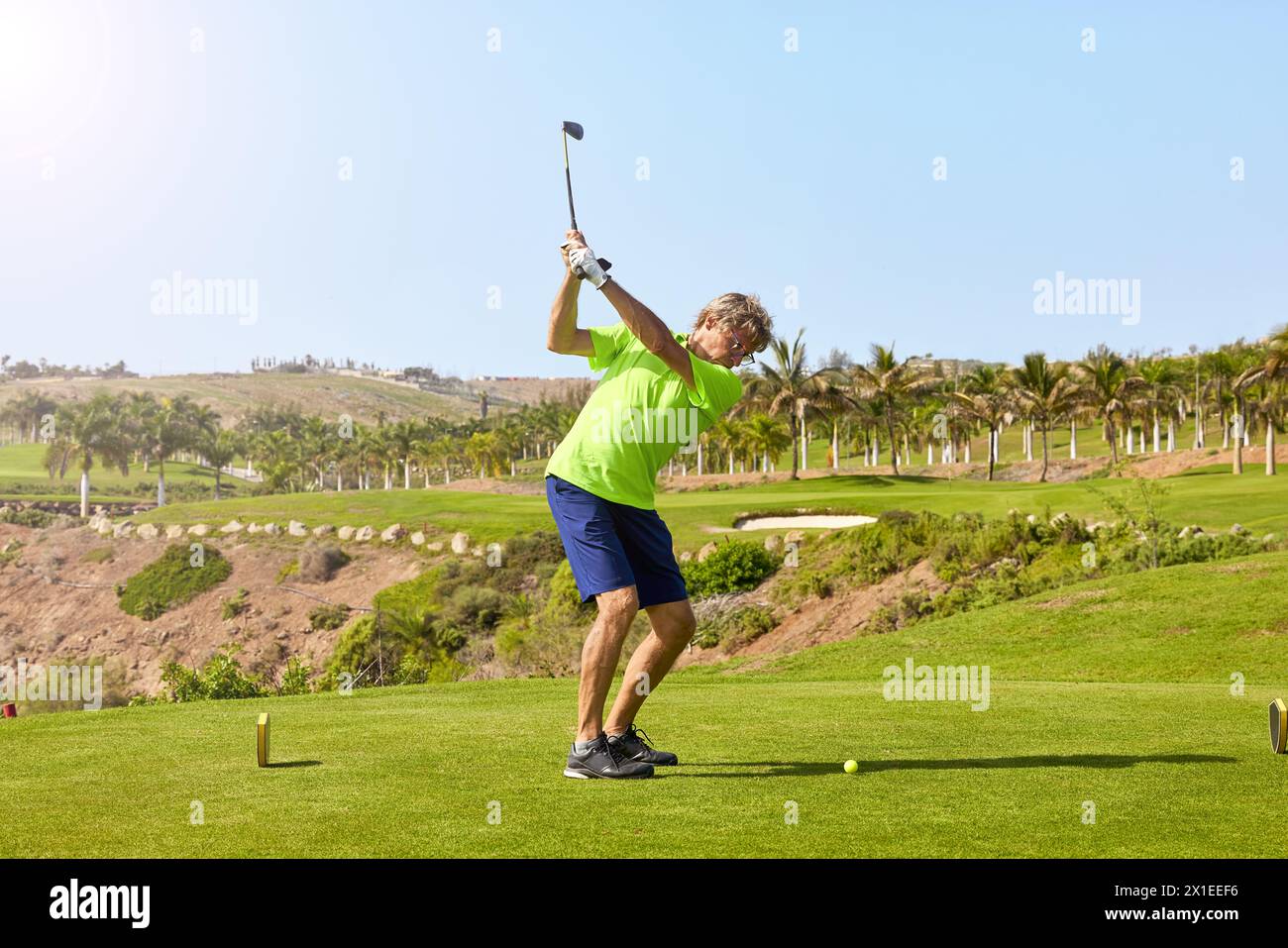 Golfer on a golf course, ready to tee off. Golfer with golf club ...