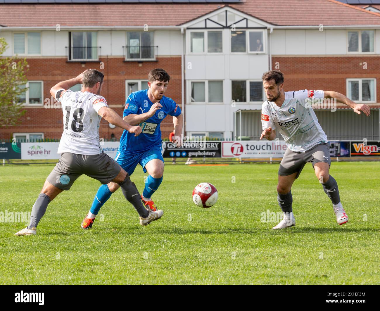 Warrington Ryland's Sam Burns runs through two defenders with the ball ...