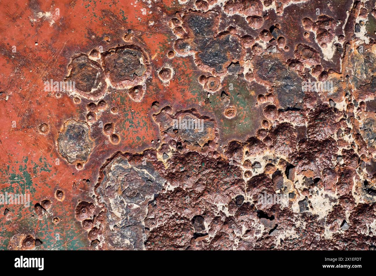 The image is of a rusty surface with many small holes. The surface is ...