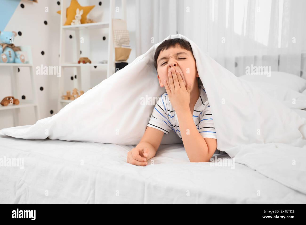 Cute little boy yawning in bedroom Stock Photo - Alamy
