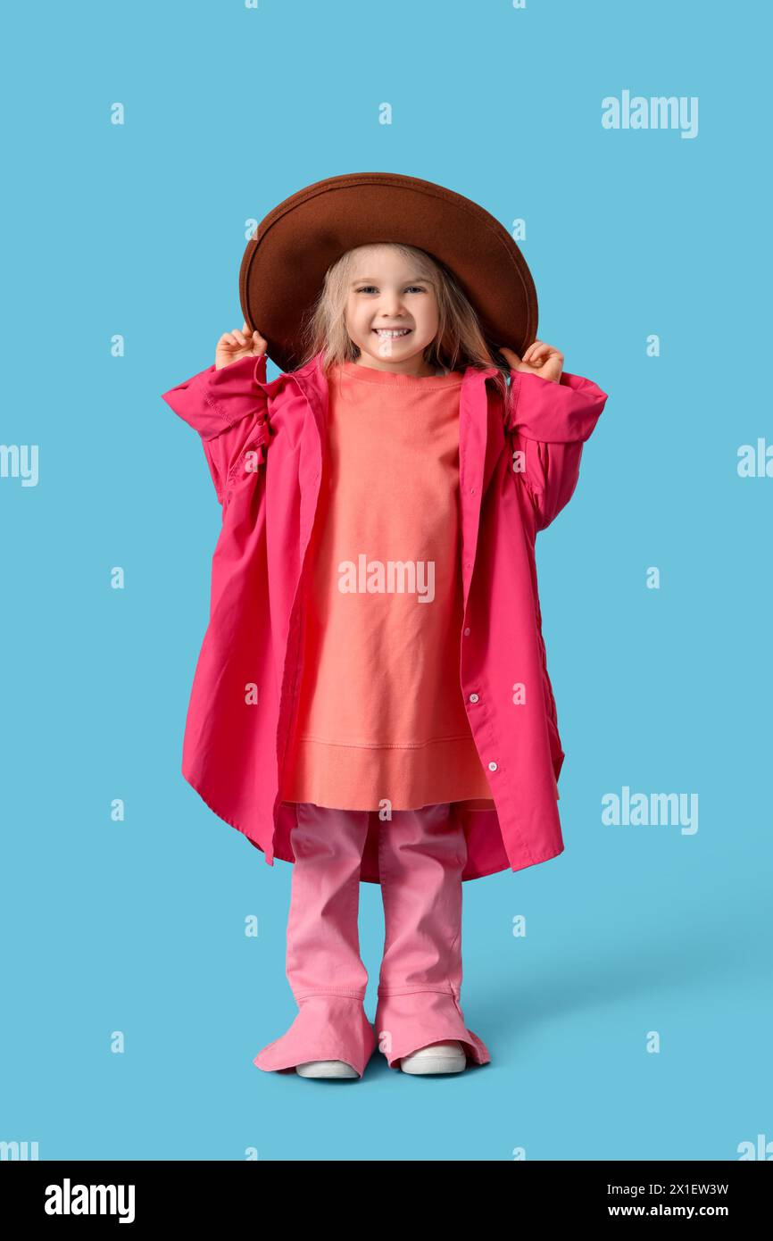 Cute little girl in adult clothes on blue background Stock Photo - Alamy