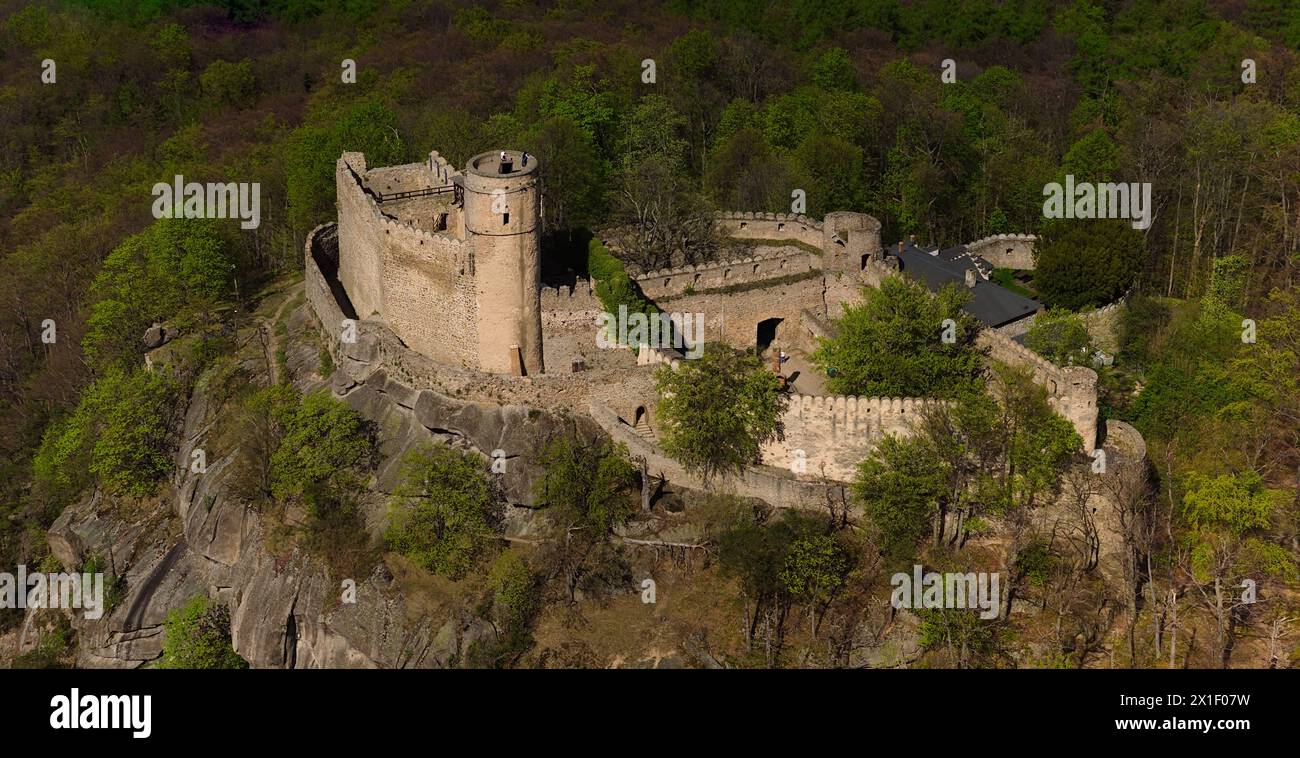 An aerial view captures the medieval Chojnik Castle atop a mountain in ...