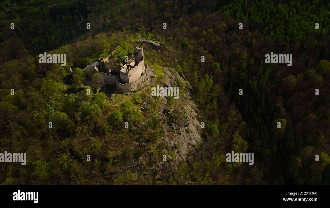 An aerial view captures the medieval Chojnik Castle atop a mountain in ...