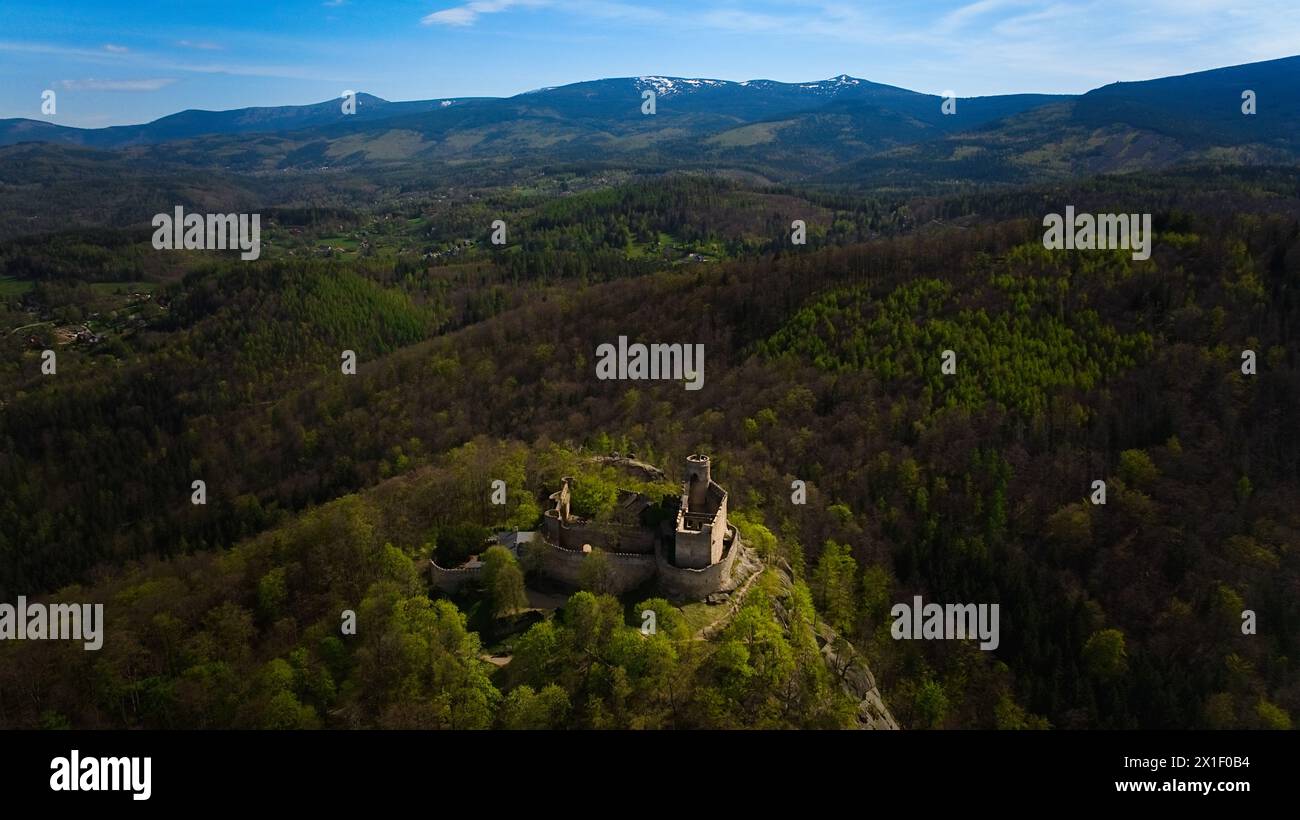 An aerial view captures the medieval Chojnik Castle atop a mountain in ...