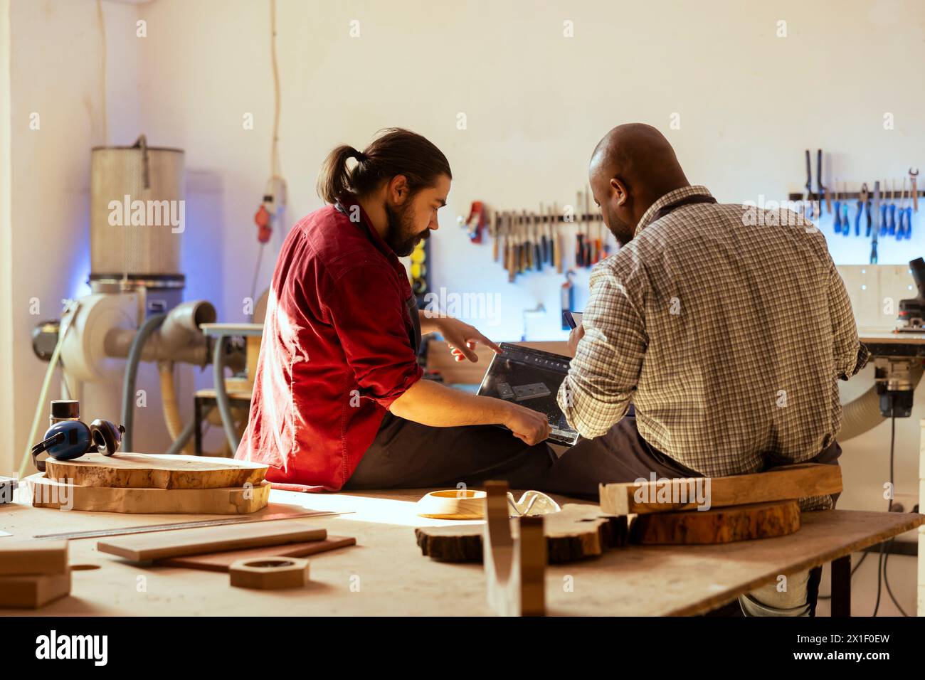 Carpenter looking over blueprints schematics on laptop in CAD software ...