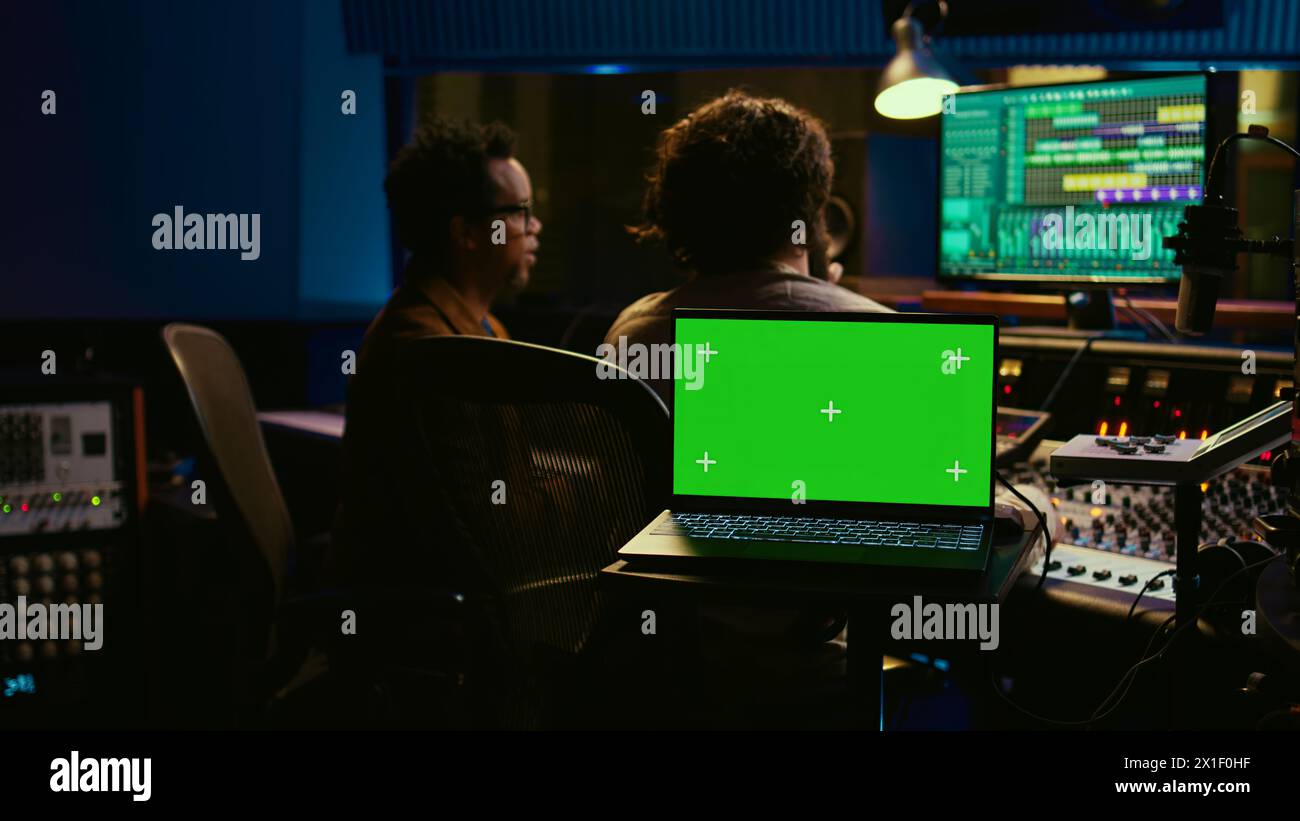 Team of artist and music producer work with mockup display, processing ...