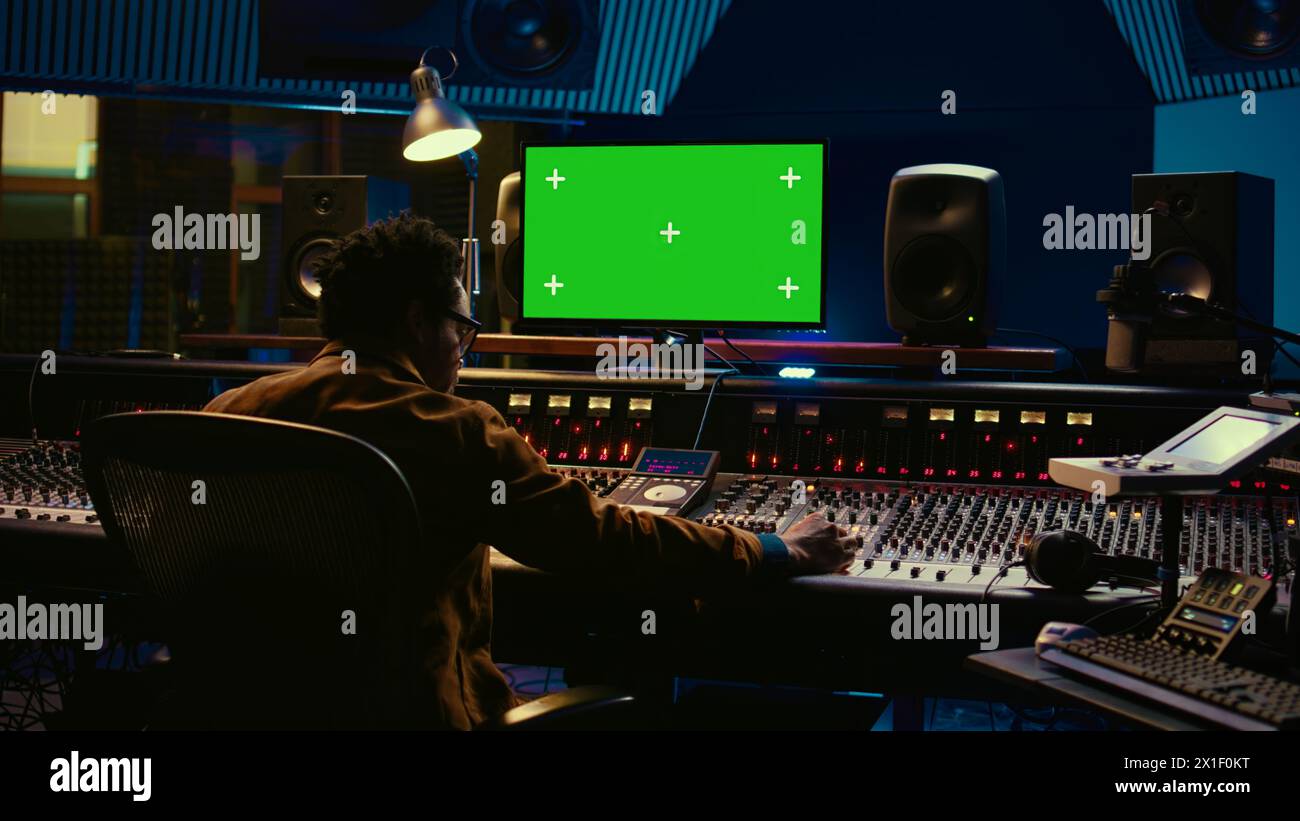 African american music producer working with greenscreen on pc, using ...