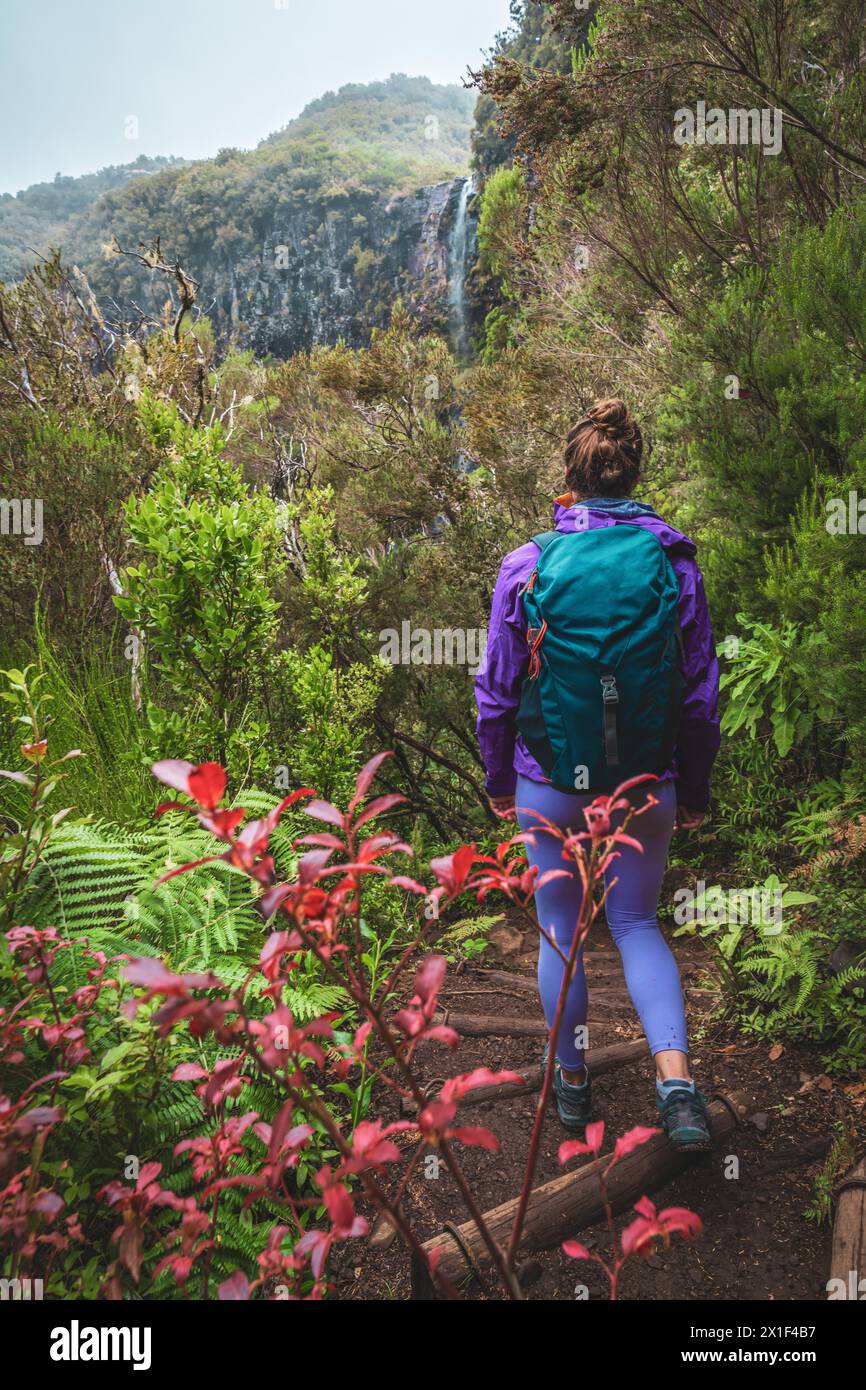 Description: Female tourist with backpack hikes along a curved forest ...