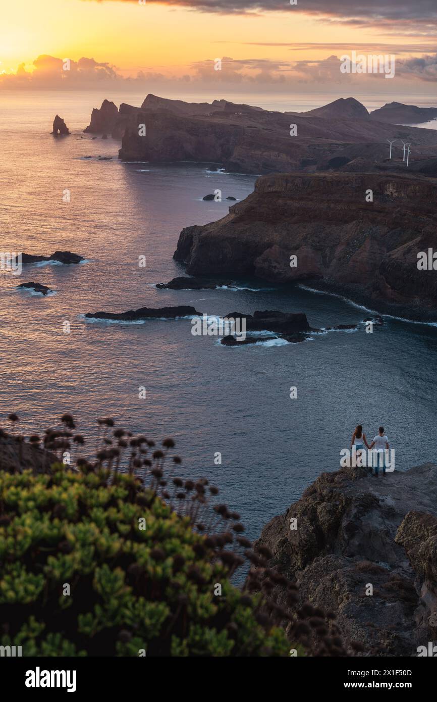 Description: Tourist pair enjoys panoramic sunrise from a vantage point ...