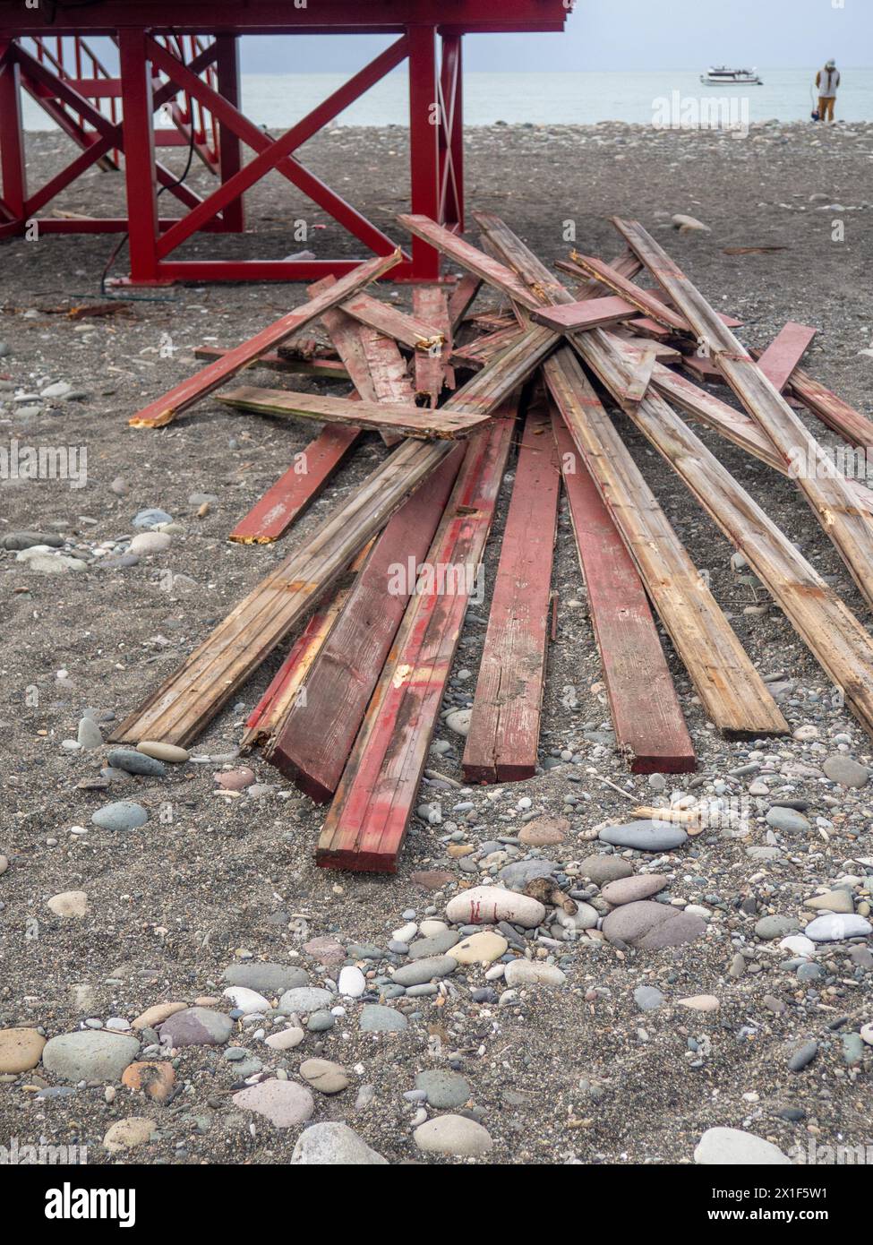 Old red boards on the sand. garbage. A mountain of wood. The building ...