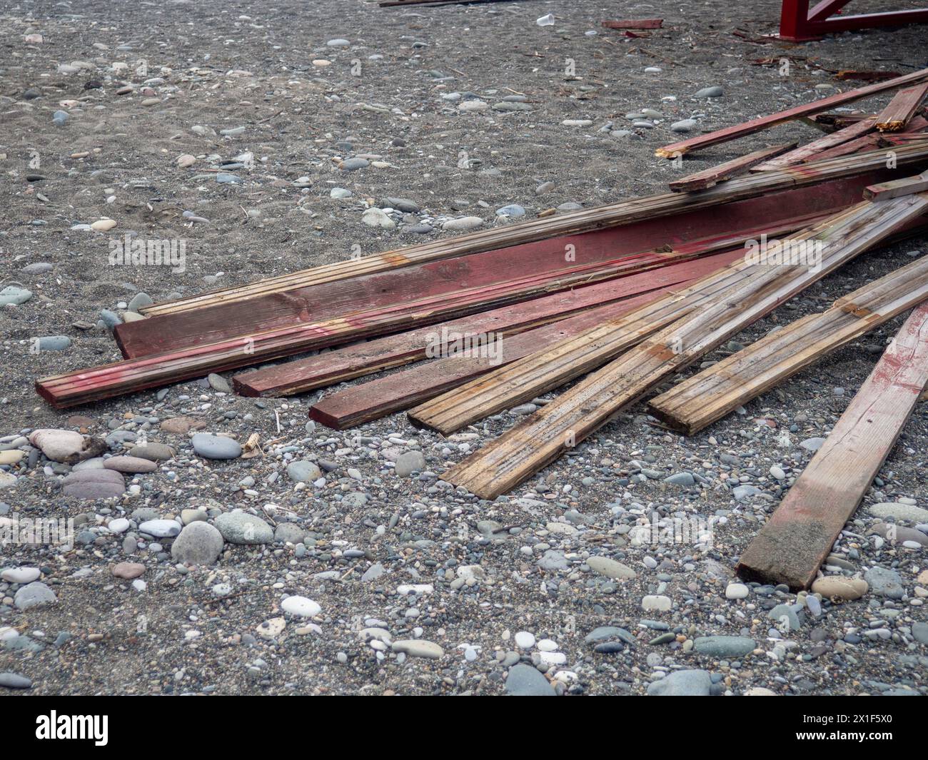 Old red boards on the sand. garbage. A mountain of wood. The building ...