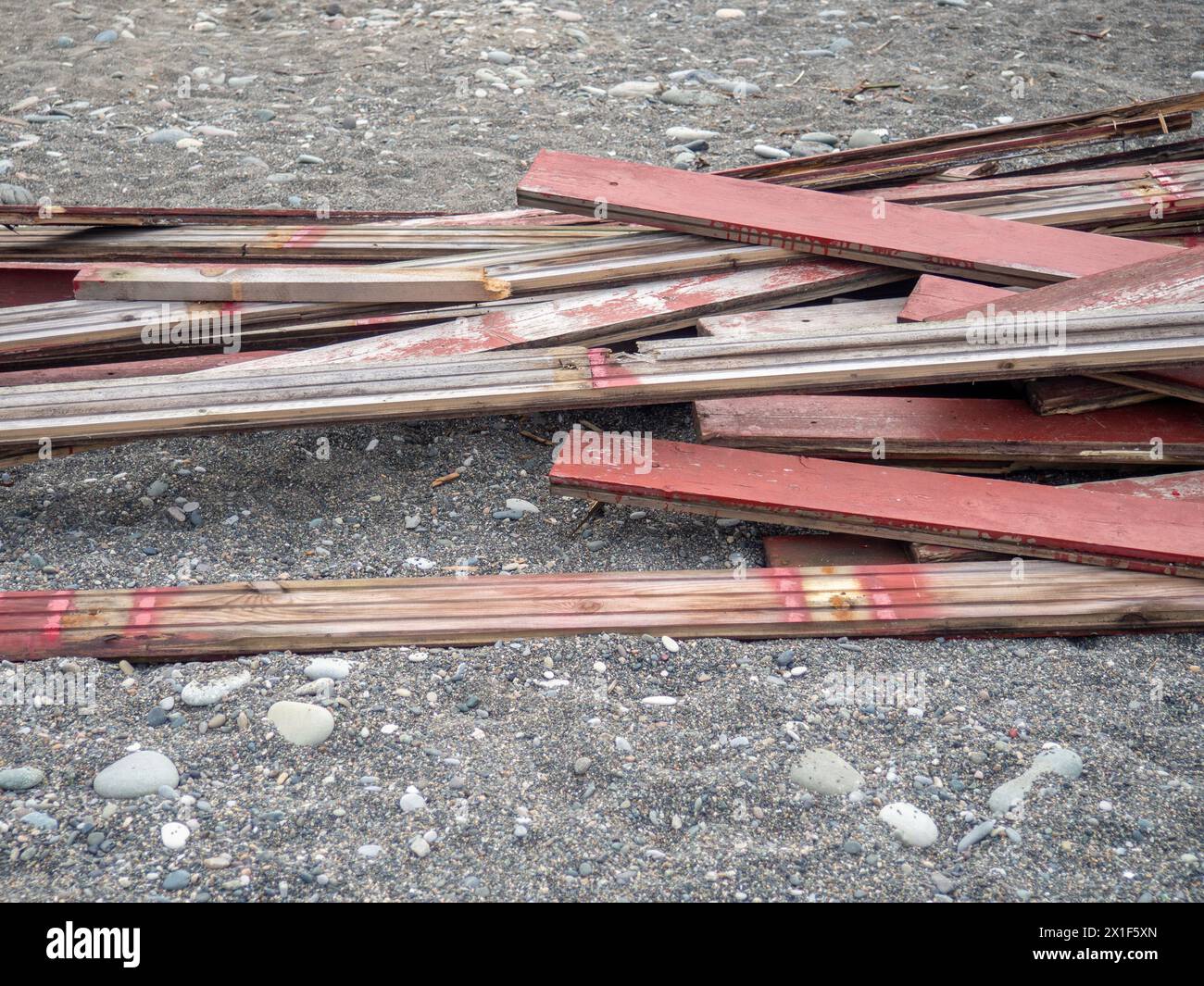 Old red boards on the sand. garbage. A mountain of wood. The building ...