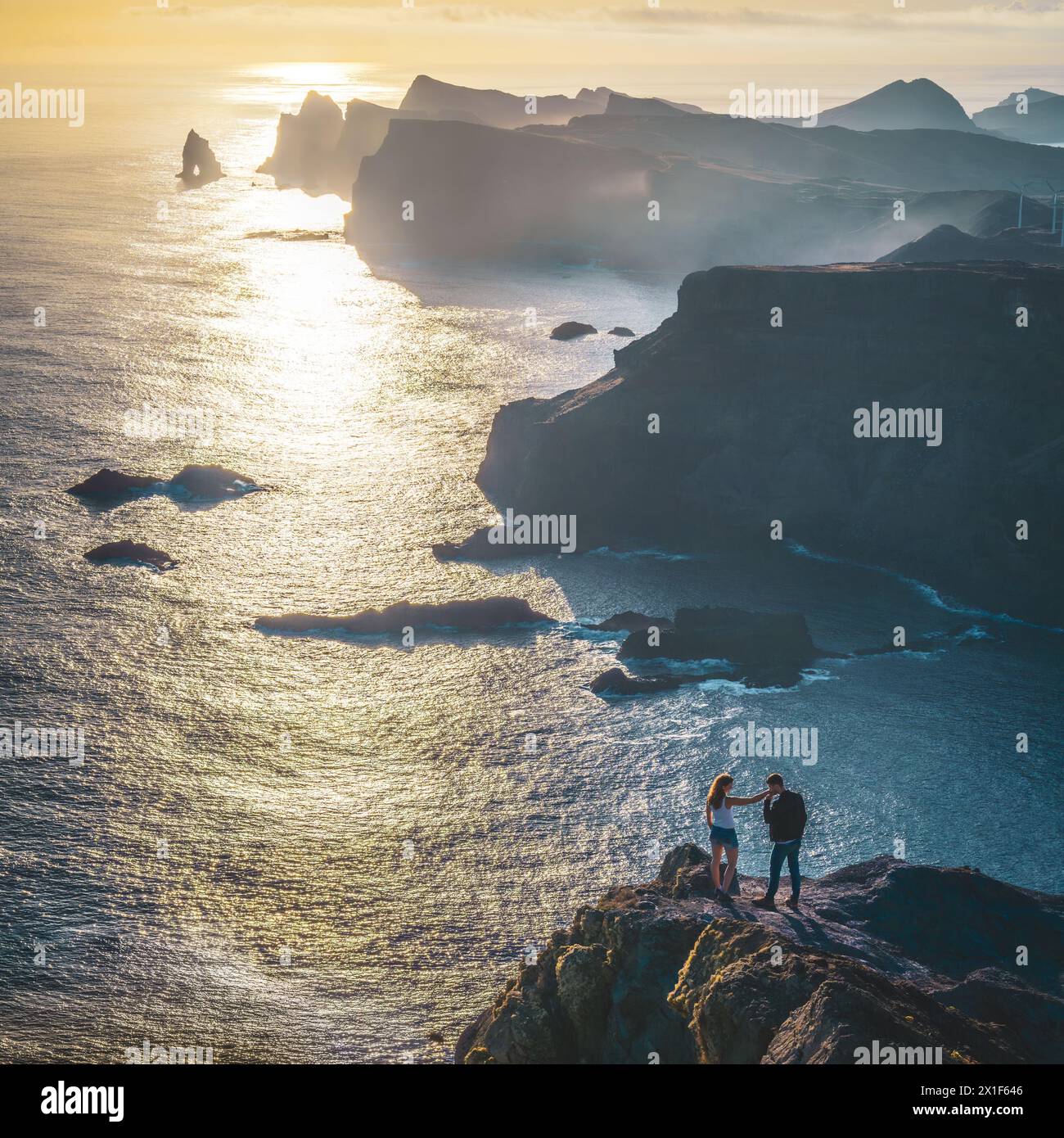 Description: Tourist kisses his girlfriend's hand at viewpoint on steep ...