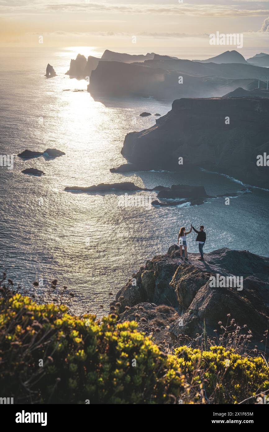 Description: Tourist couple slaps hands from a stunning vantage point ...