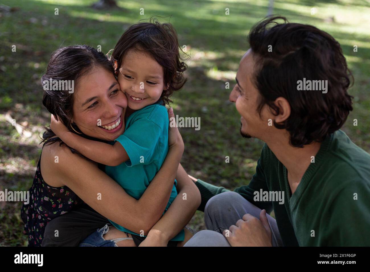 Young Latino parents happily share with their 3 year old son at the ...