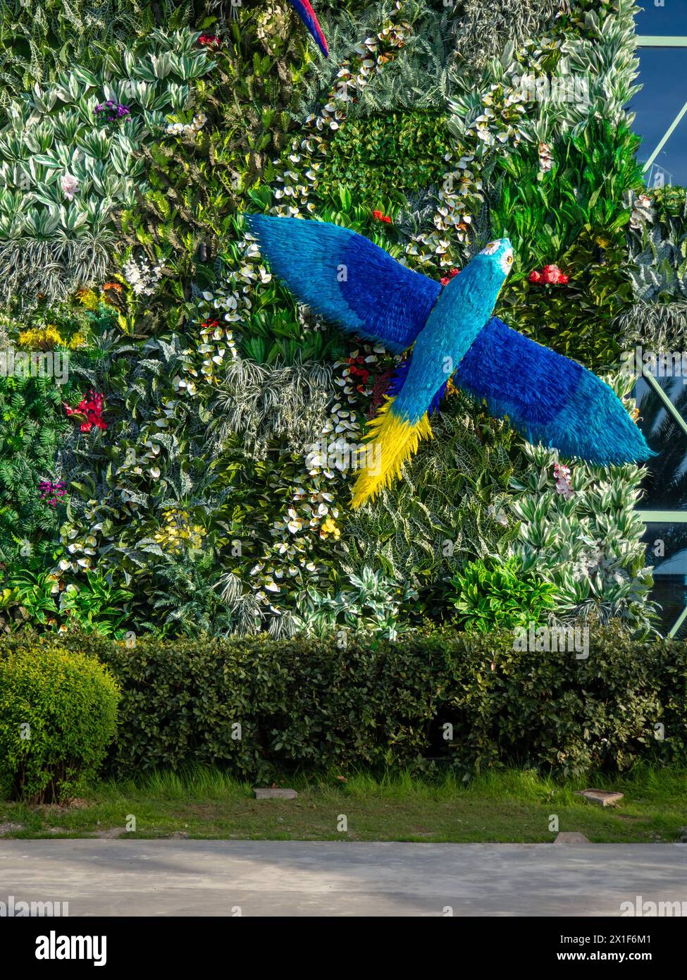 facade of the building is decorated with artificial birds. Parrots made ...