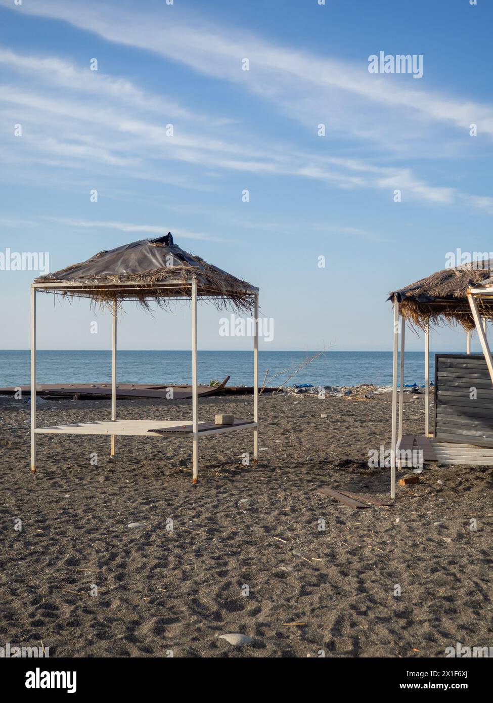 Abandoned decorative houses with thatched roofs on the seashore. Off ...