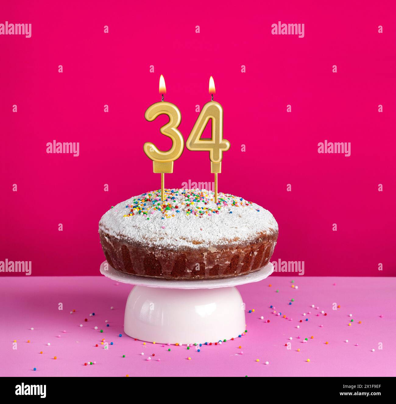 Lighted birthday candle number 34 - Birthday card on pink background ...
