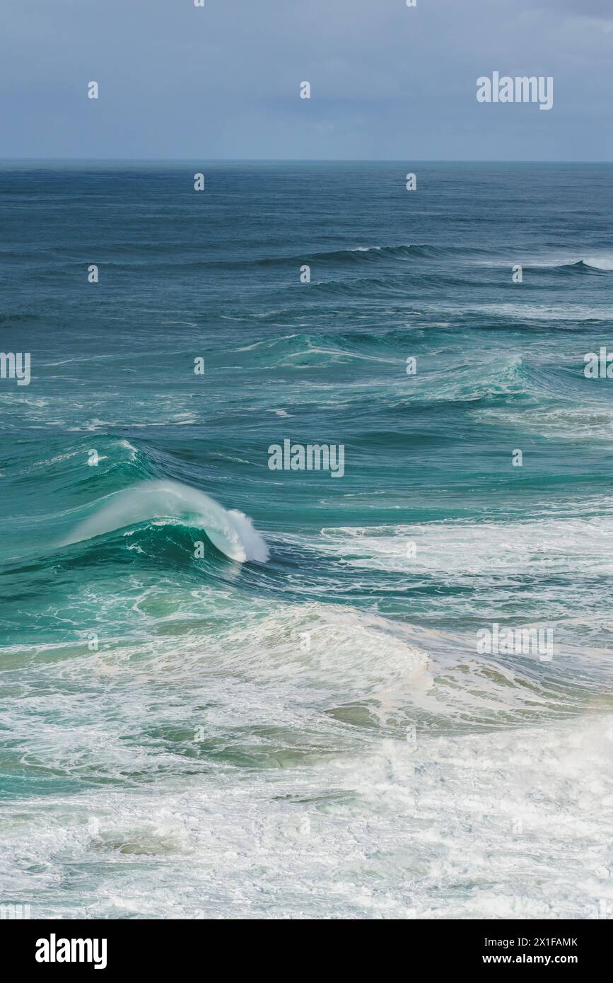 A magnificent wave curls with frothy white foam at Nazare, known for ...