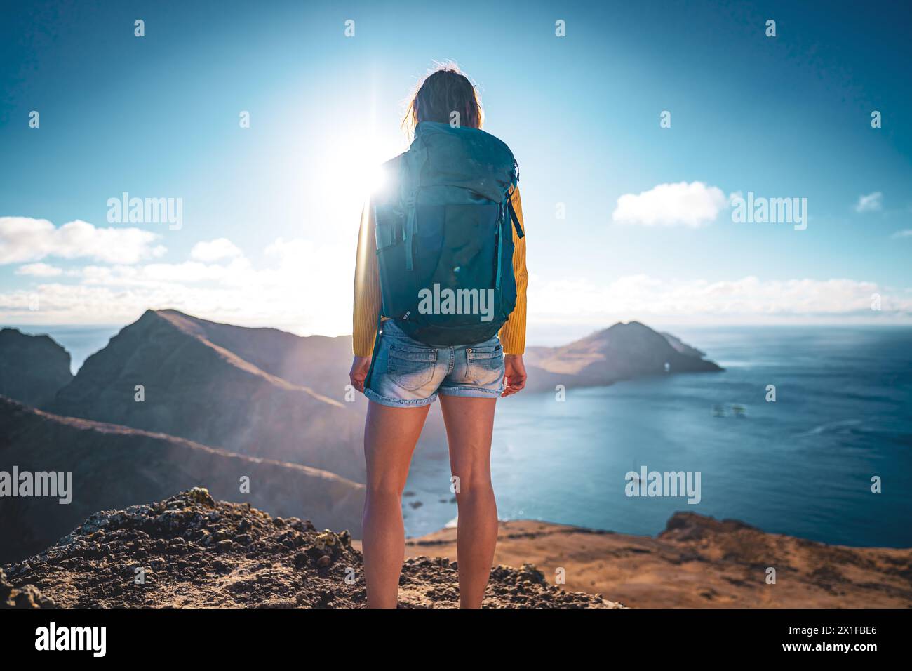 Description: Low angle back view of a tourist backpacker standing on ...