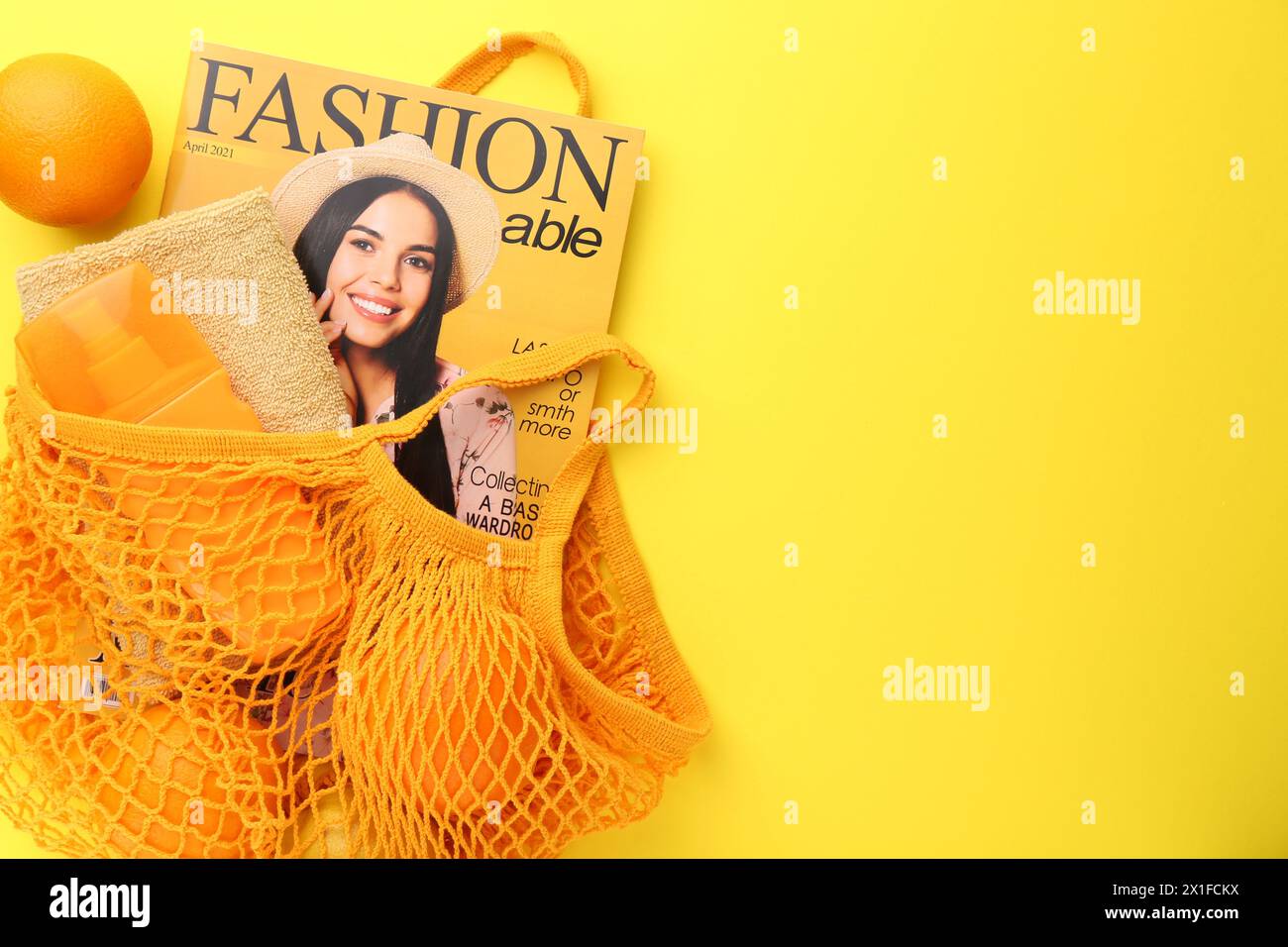 String bag with fresh oranges, fashion magazine and beach accessories ...