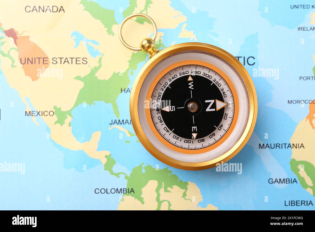 Compass on world map, top view. Navigation equipment Stock Photo - Alamy