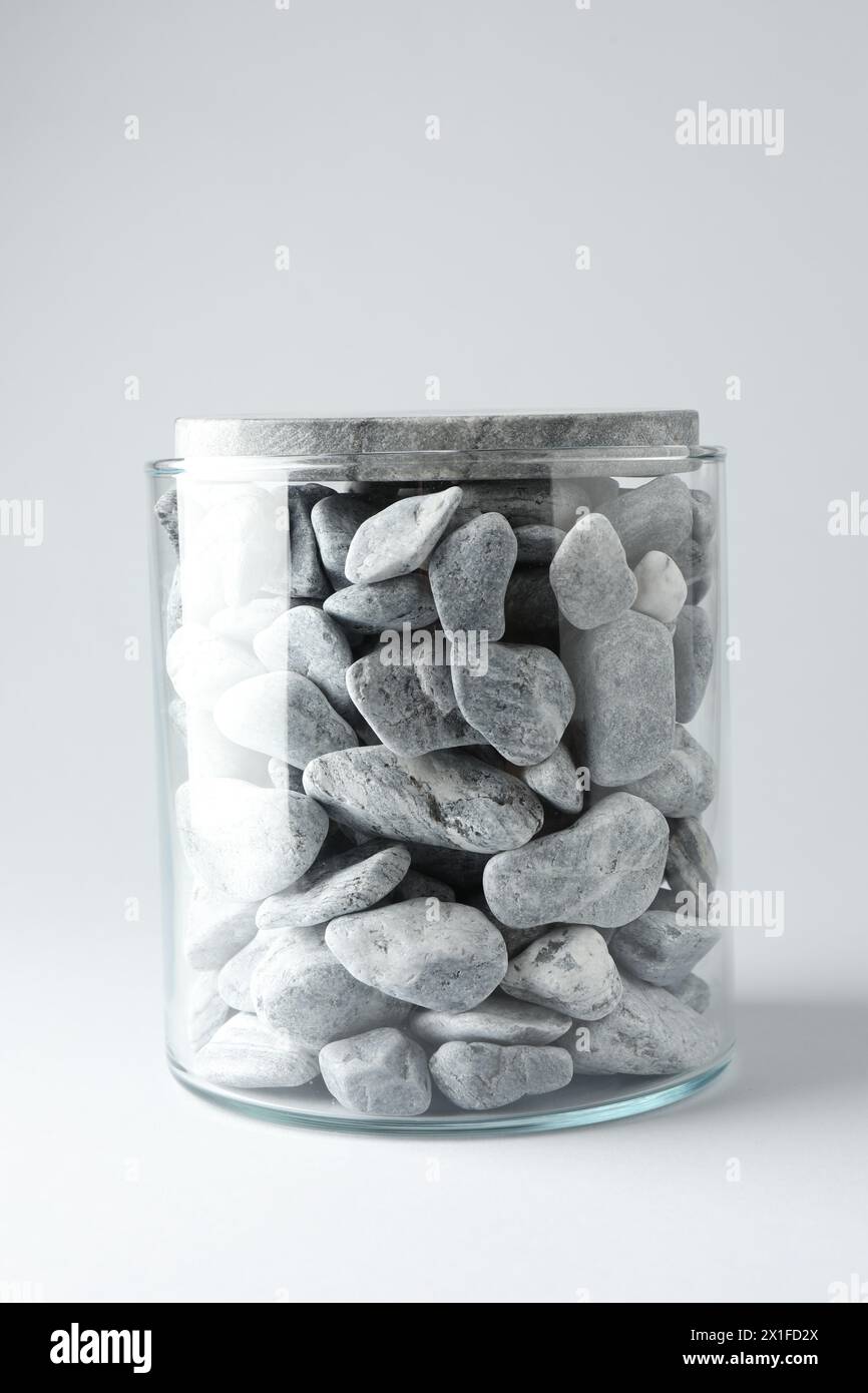 Presentation for product. Glass container with stones on light grey ...