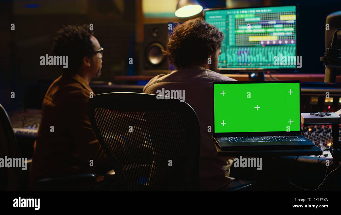 Team of artist and music producer work with mockup display, processing ...