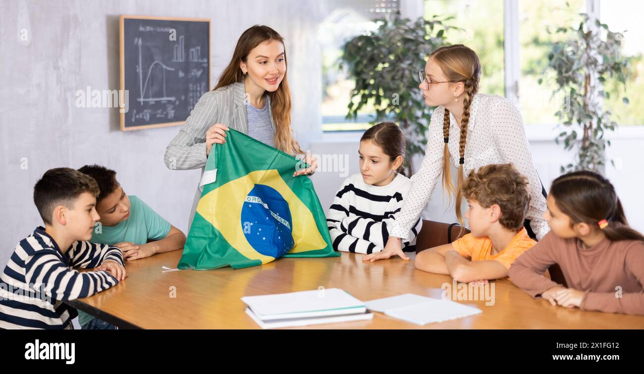 Teacher showing Brazil flag to group of schoolchildren Stock Photo - Alamy