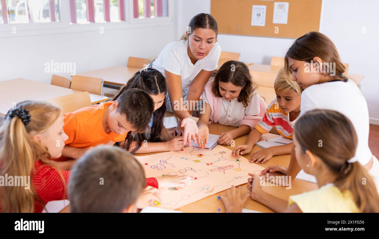 Teacher and pupils playing board game in school Stock Photo - Alamy